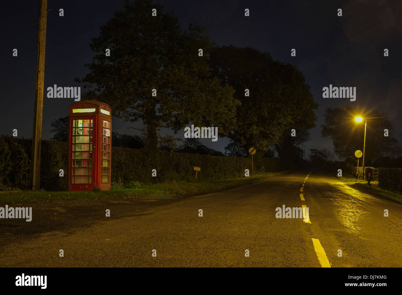 Lone Red Telephone box on a country lane at night Stock Photo - Alamy