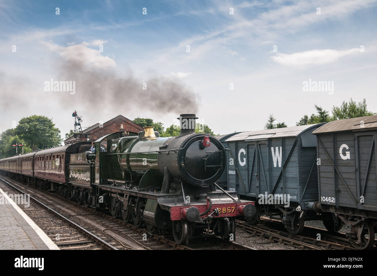 Lovely old steam engine pulling carriages next to freight trucks puffs ...