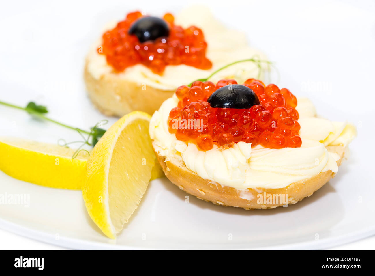 canape with red caviar and lemon on white background Stock Photo - Alamy