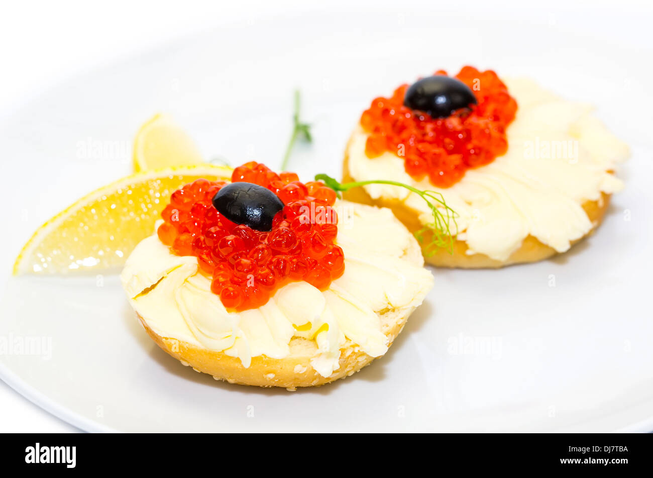 canape with red caviar and lemon on white background Stock Photo - Alamy