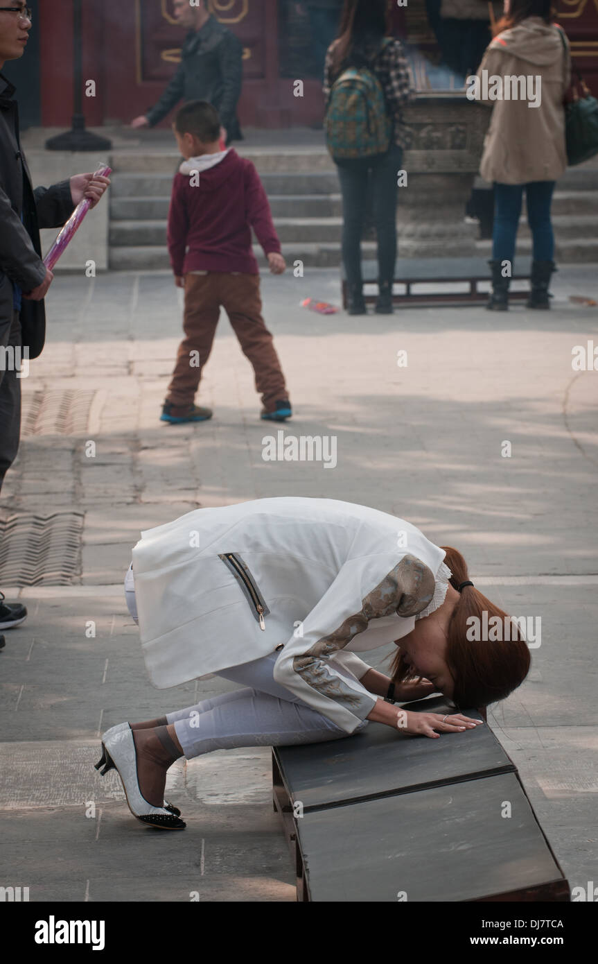 Woman praying in Yonghe Temple also known as Yonghe Lamasery or simply ...
