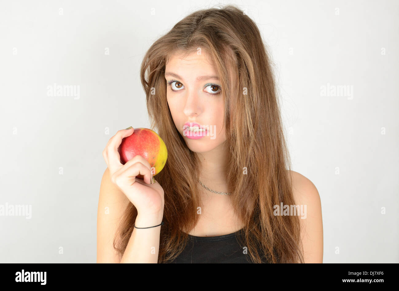 Pretty, young girl holding apple. Female model showing healthy ...