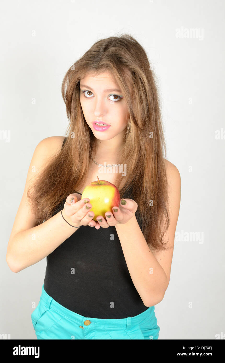 Pretty, young girl holding apple. Female model showing healthy ...