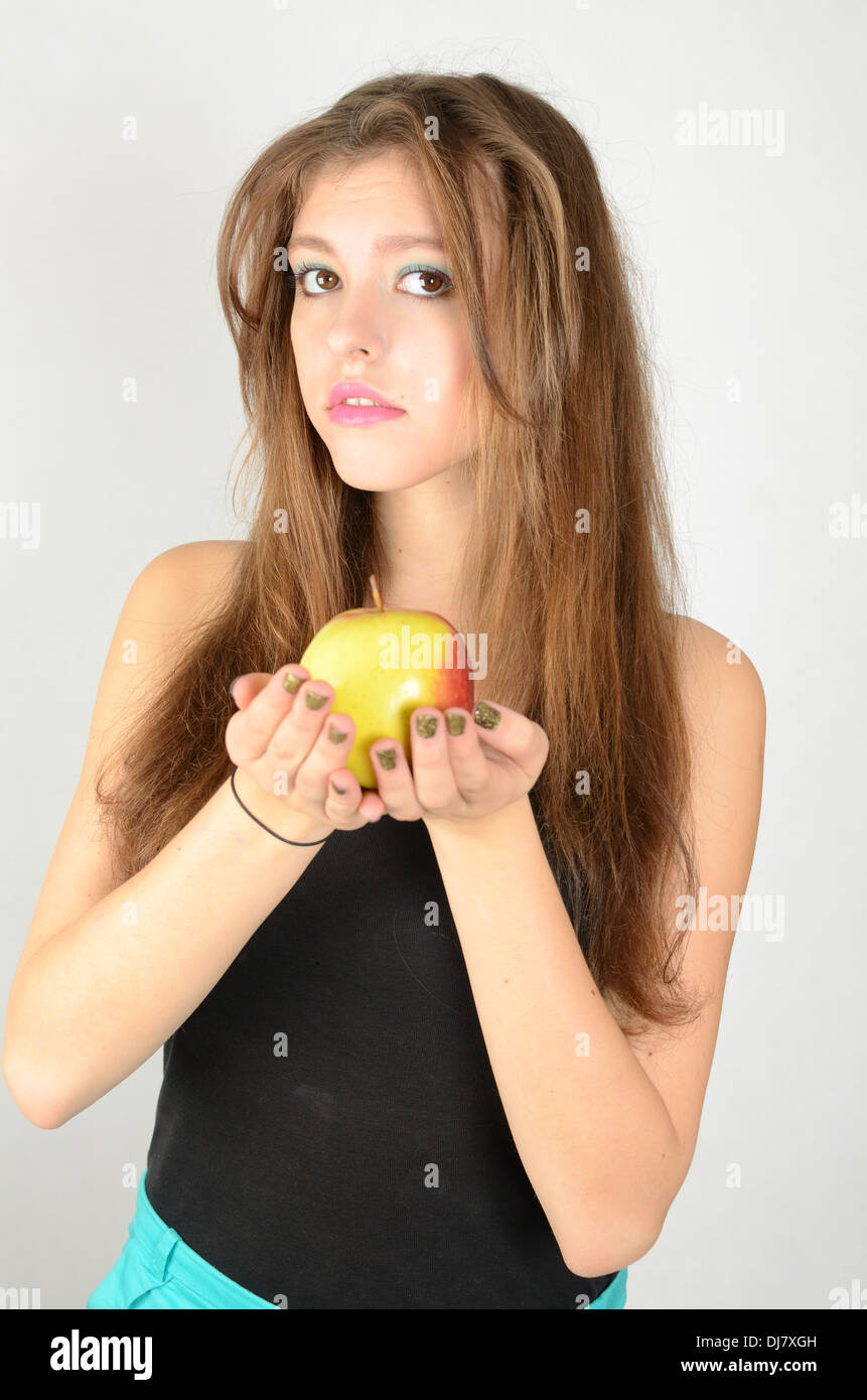 Pretty, young girl holding apple. Female model showing healthy ...