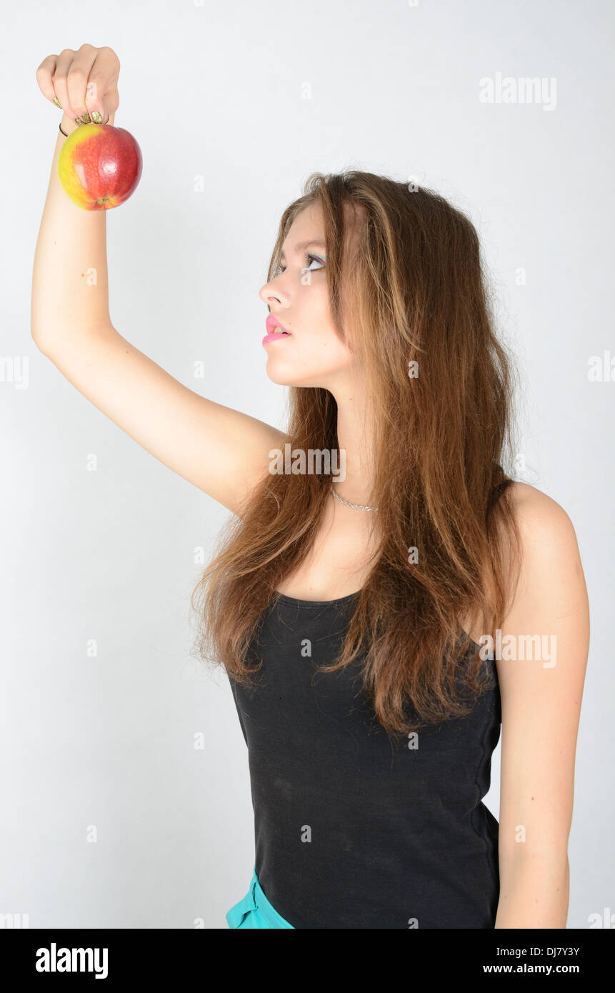 Pretty, young girl holding apple. Female model showing healthy ...
