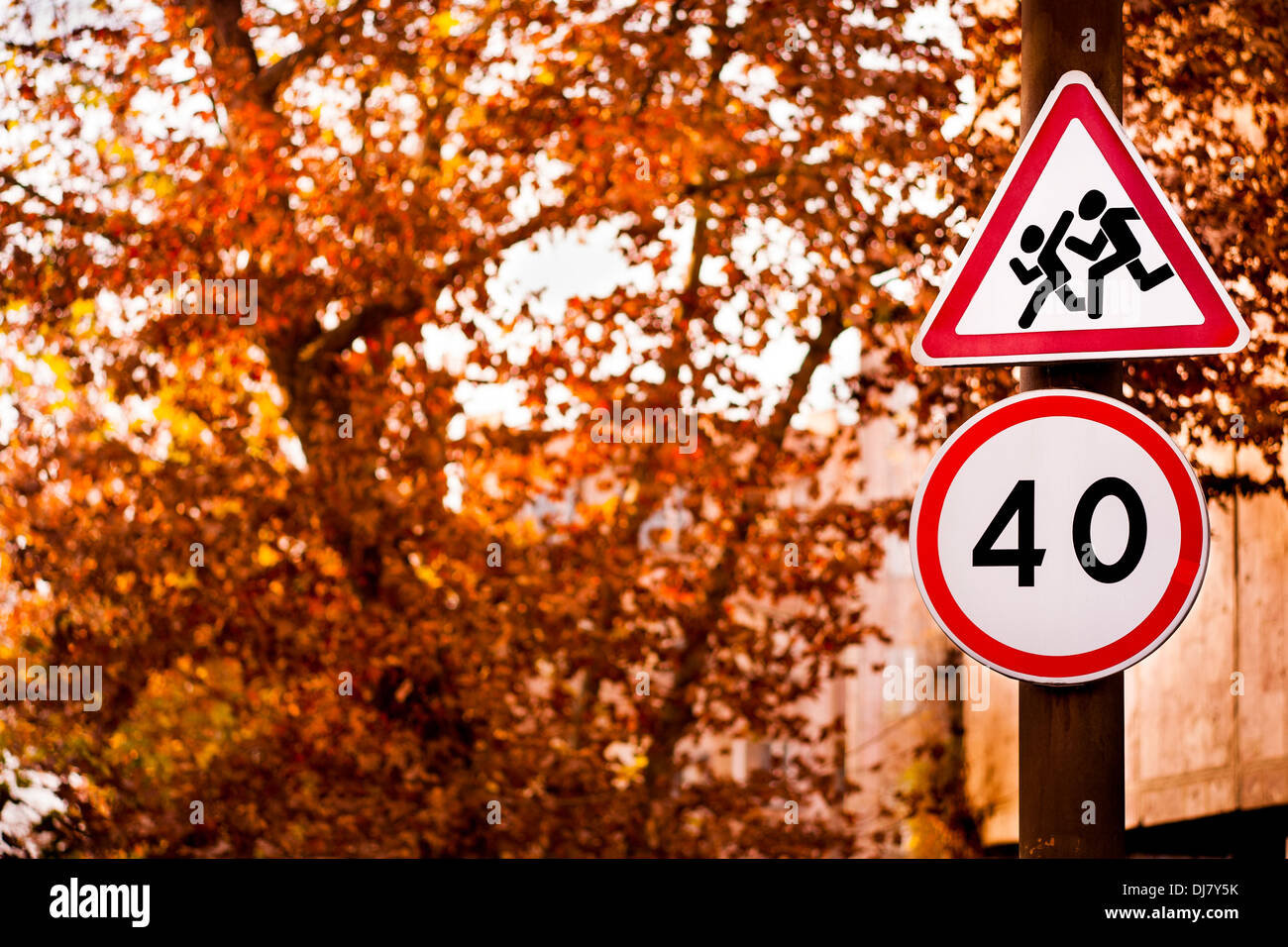 Road sign with running children and a 40 speed limit sign on an autumn ...