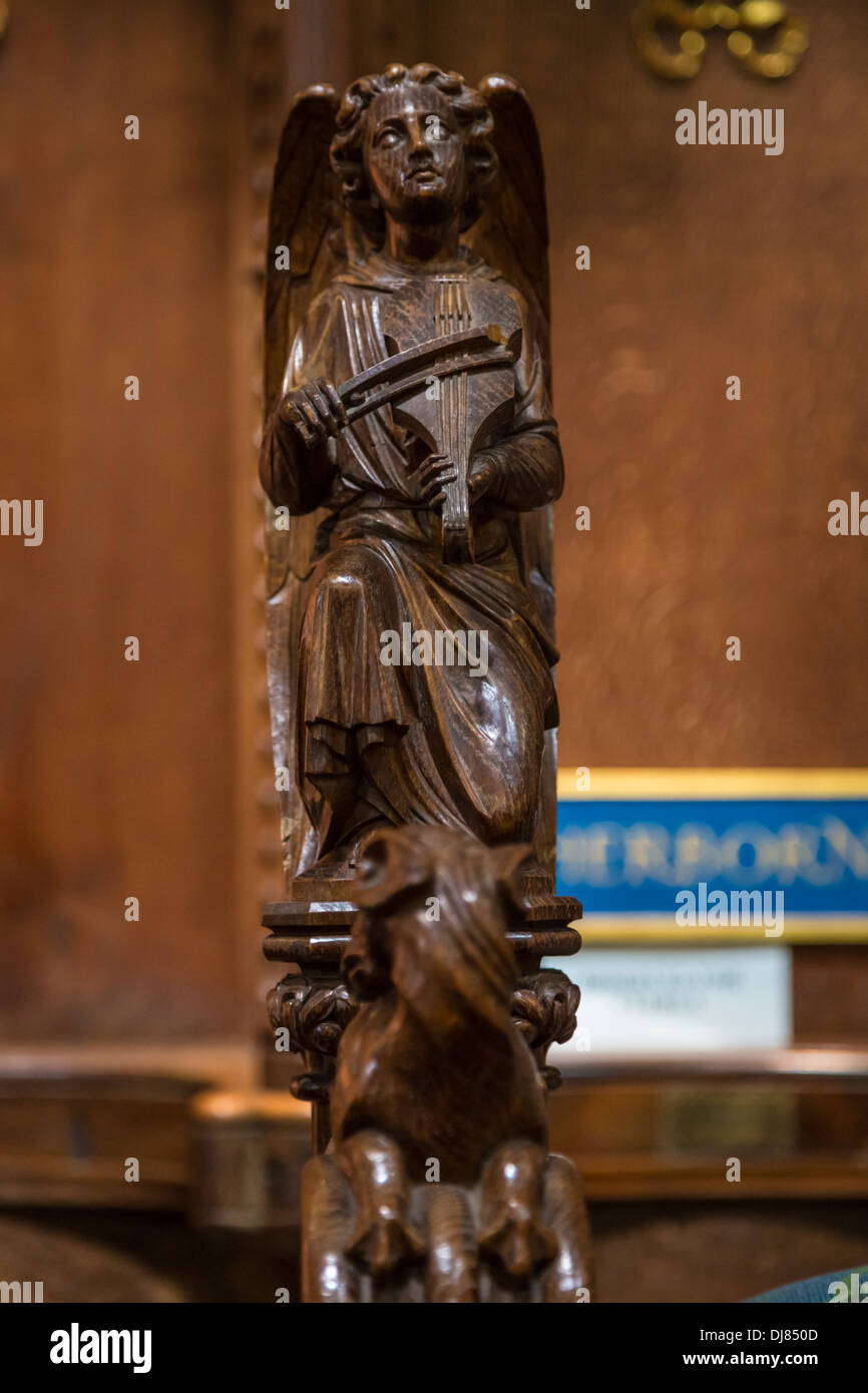 Wooden carved angel playing string instrument in Salisbury Cathedral ...