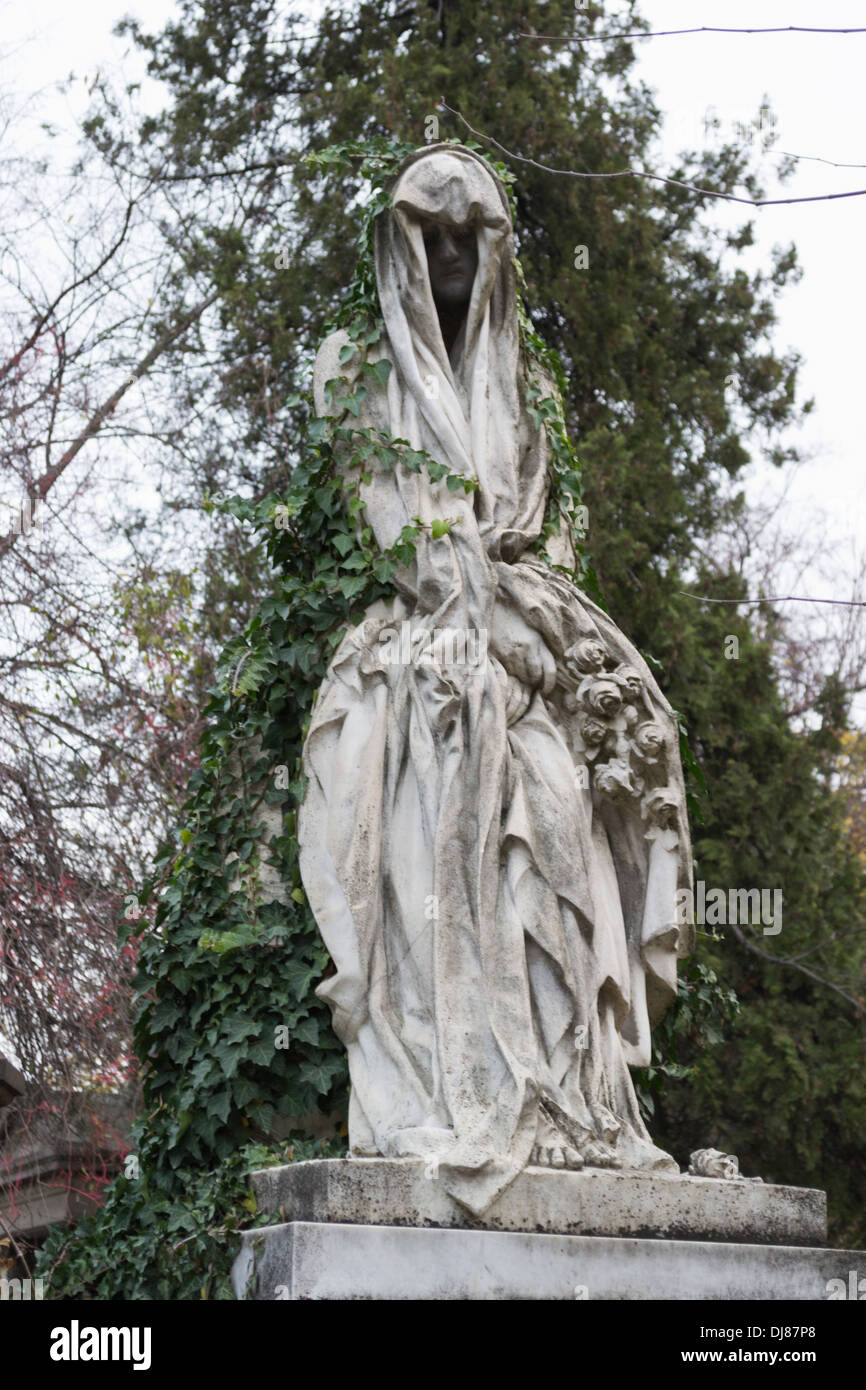 Statue of a mourning woman with dreadful eyes bringing roses to the ...