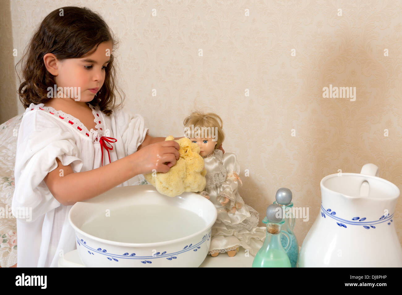 Adorable little victorian girl washing her vintage doll Stock Photo - Alamy