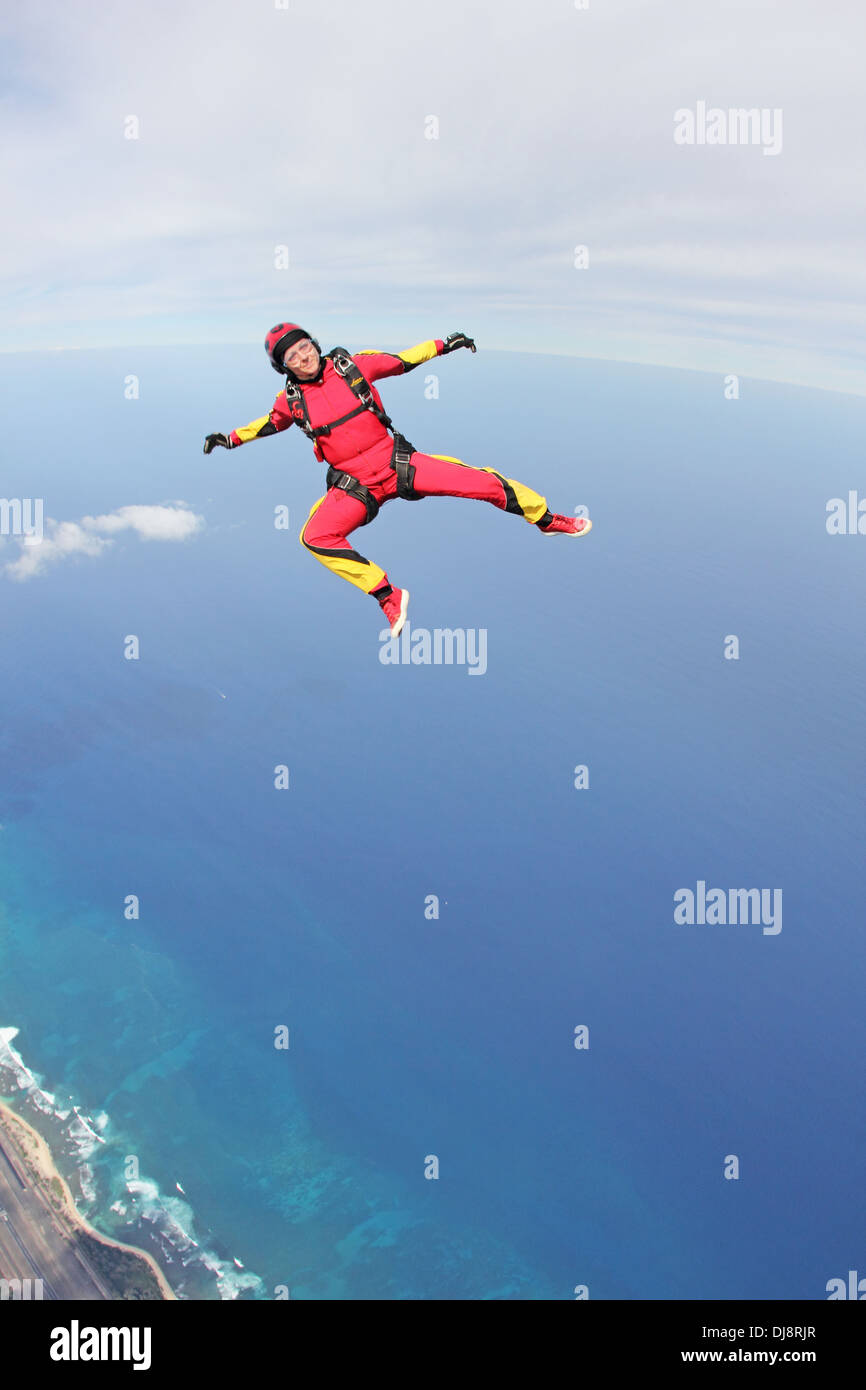This skydiver girl is flying in a free style position over the deep ...
