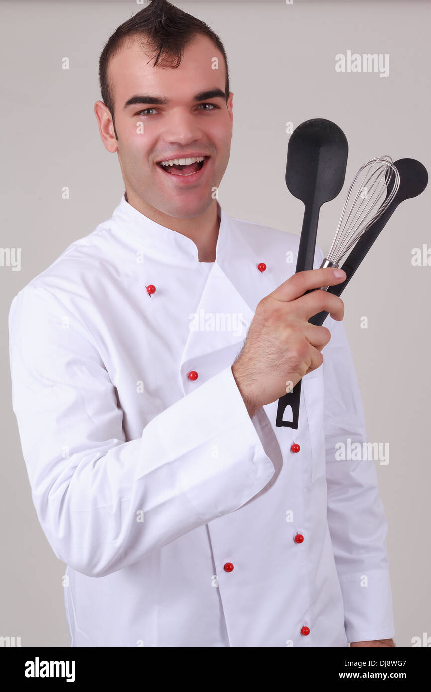 Laughing chef brandishing kitchen utensils Stock Photo - Alamy