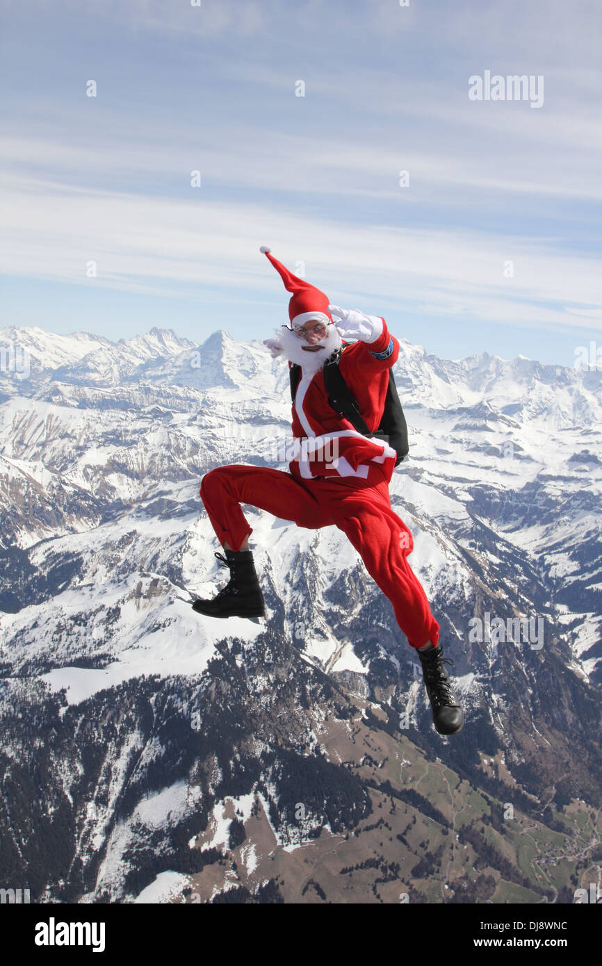 This skydiver is falling free in a Santa Claus costume over a white ...