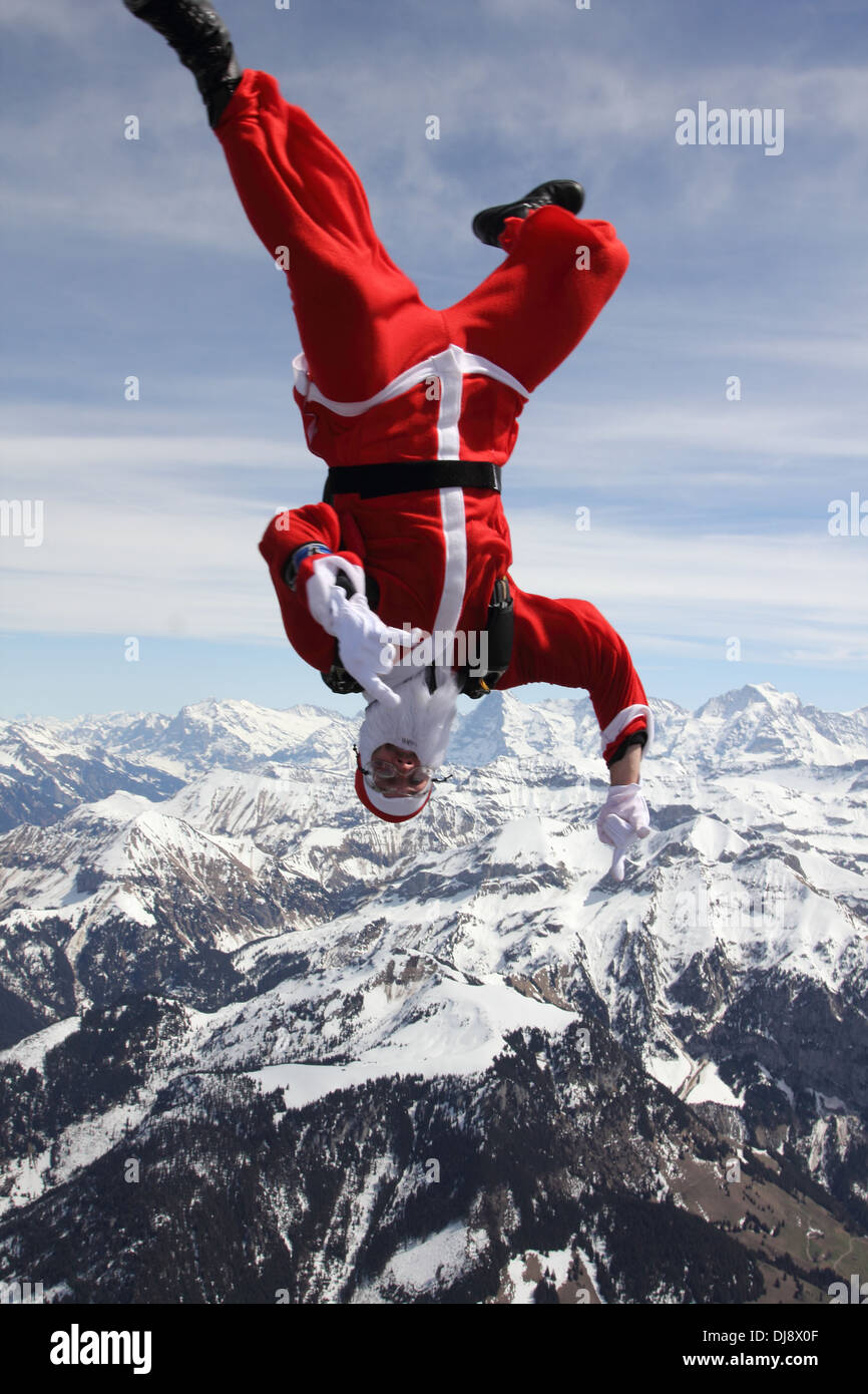 This skydiver is falling head over in a Santa Claus costume over a ...