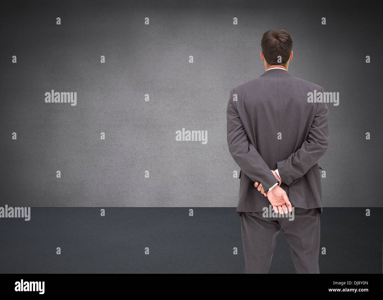 Businessman standing with hands behind back Stock Photo - Alamy