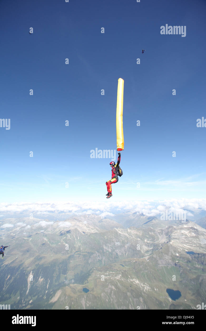 Skydiver with colorful air tube and falling through the blue sky over ...