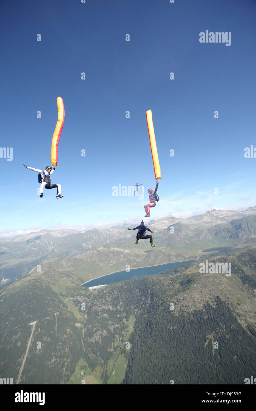 Skydivers with colorful air tubes and friends are falling through the ...