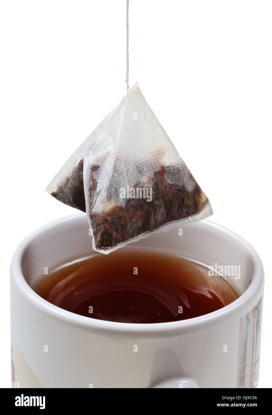 tea bag over brewing tea in mug close up isolated on white background ...