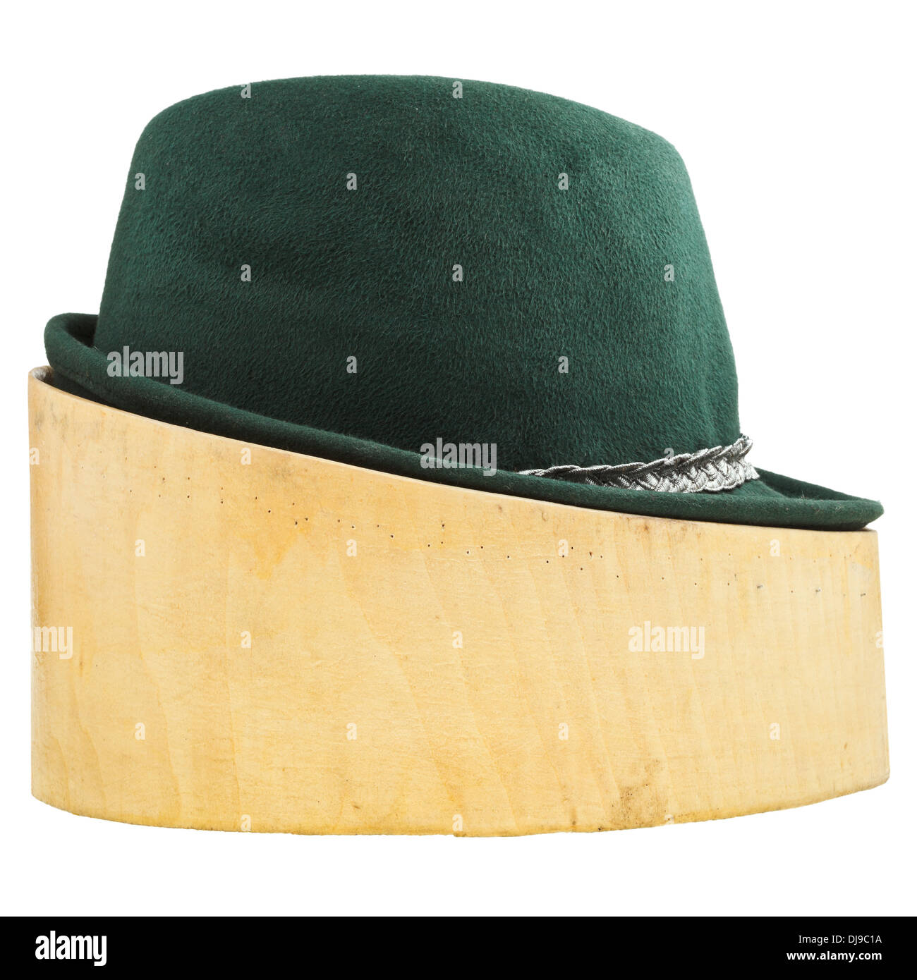 side view of green tyrolean felt hat on linden wood hat block isolated ...