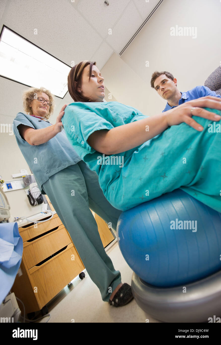Nurse Assisting Pregnant Woman Sitting On Exercise Ball Stock Photo - Alamy