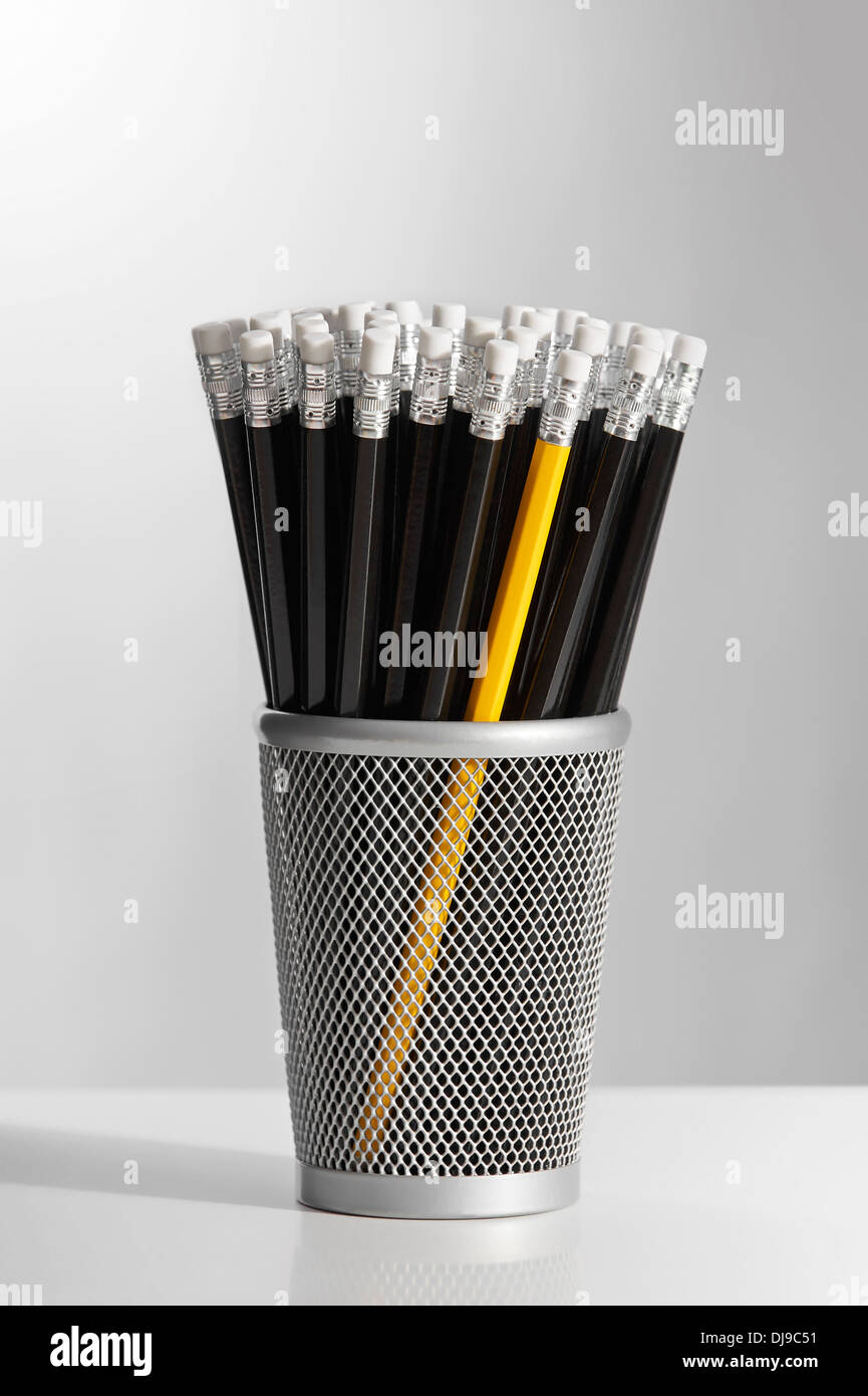 Single yellow pencil in a pot of black pencils Stock Photo - Alamy