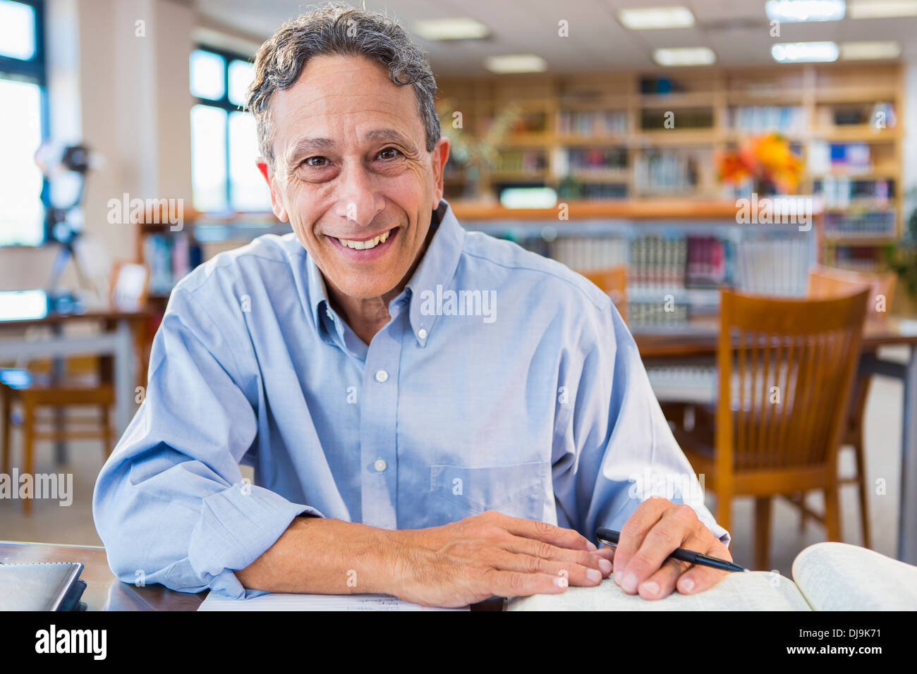 Senior man working in library Stock Photo - Alamy