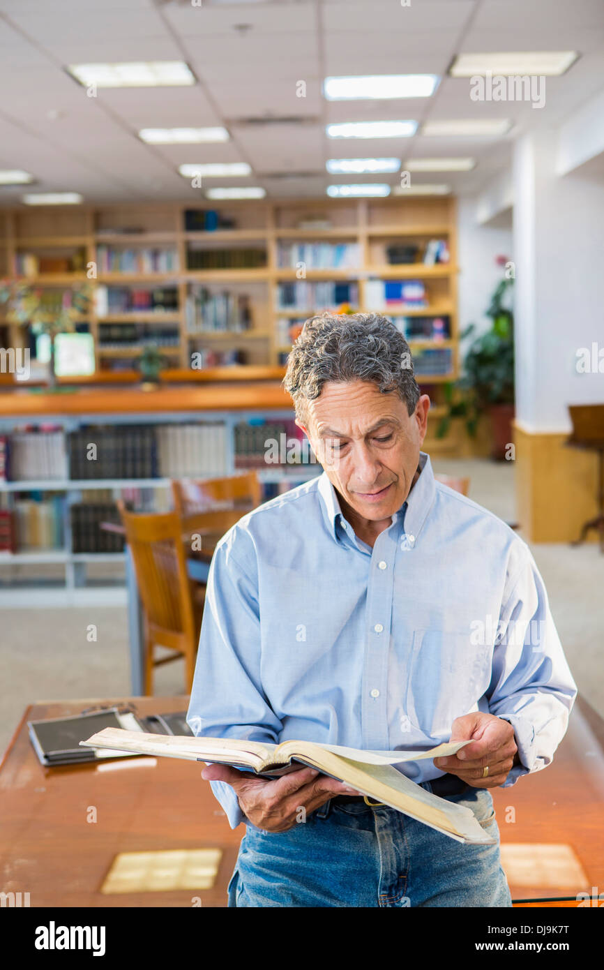 Senior man reading in library Stock Photo - Alamy