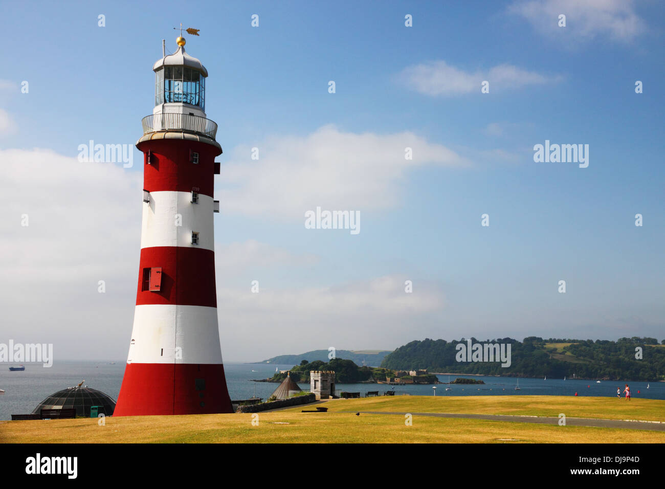 A red and white striped lighthouse overlooking a bay Stock Photo - Alamy