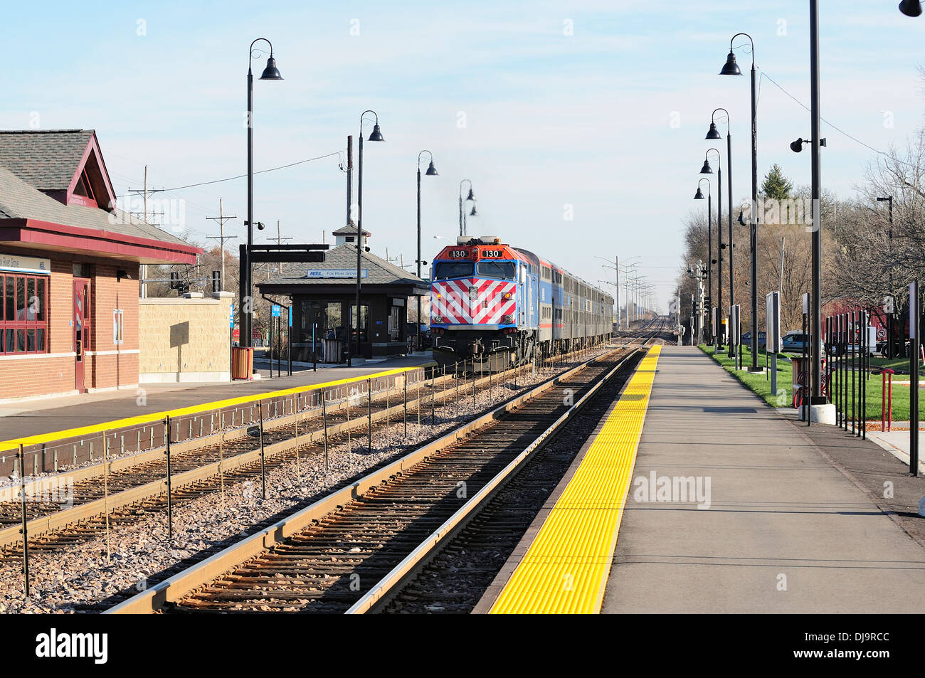 Train arriving at suburban commuter train station Stock Photo - Alamy