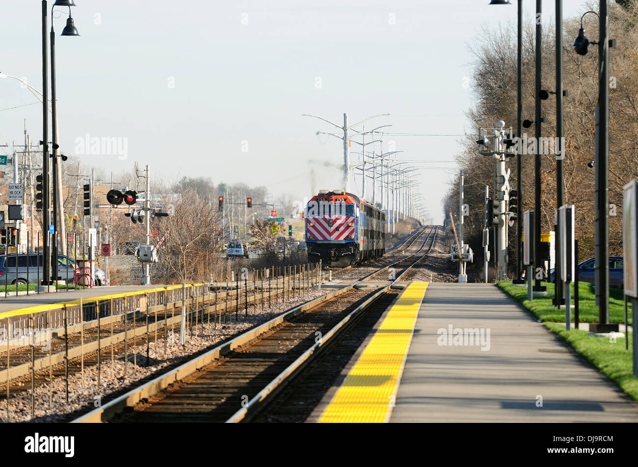 Train arriving at suburban commuter train station Stock Photo - Alamy
