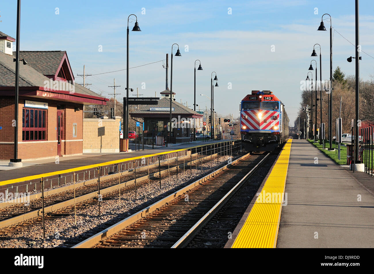 Train arriving at suburban commuter train station Stock Photo - Alamy