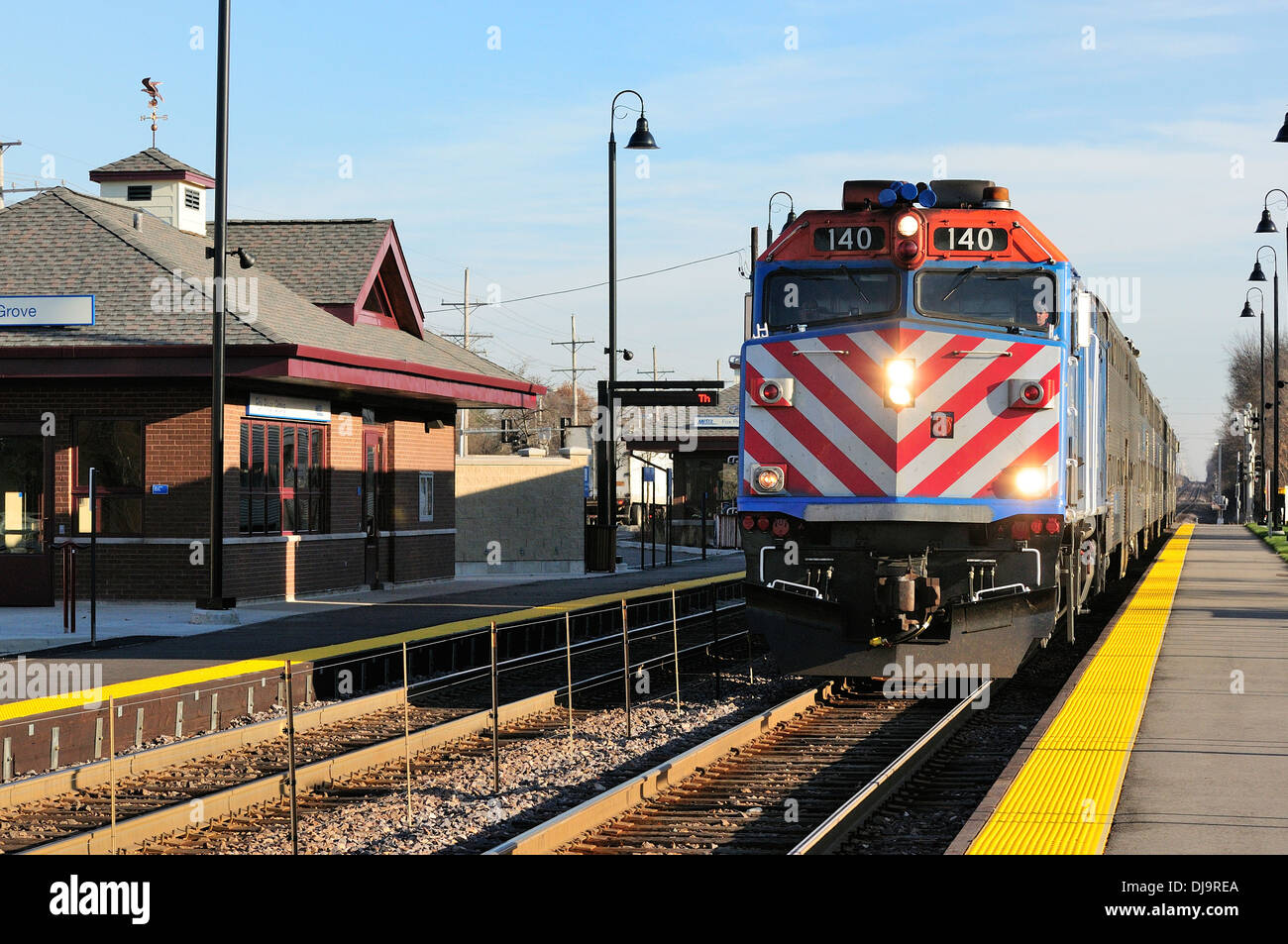 Train arriving at suburban commuter train station Stock Photo - Alamy