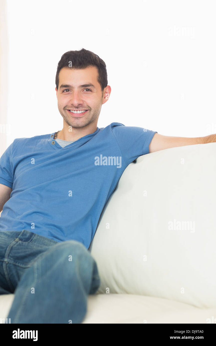 Casual content man relaxing on couch Stock Photo - Alamy