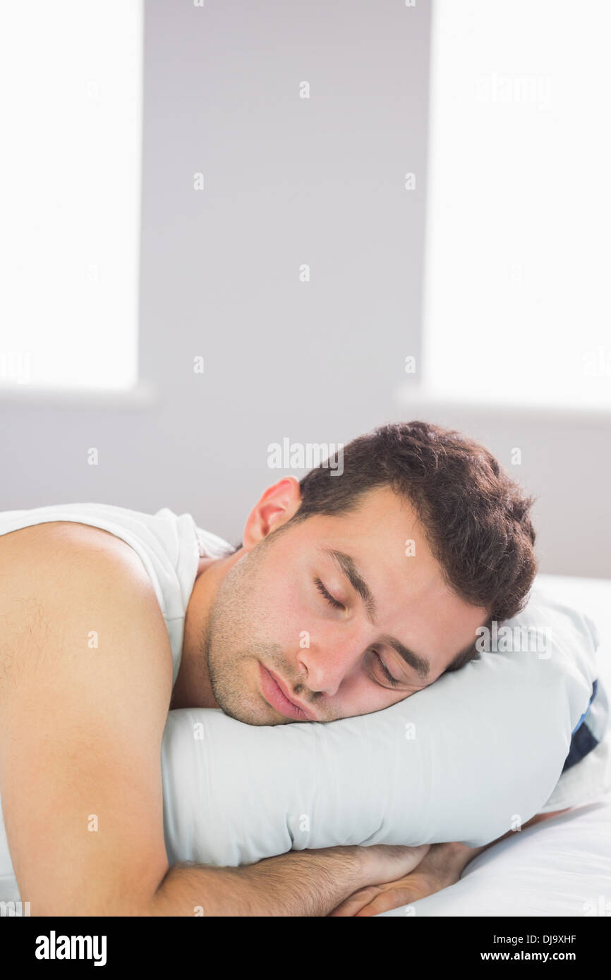 Sleepy handsome man relaxing in bed Stock Photo - Alamy