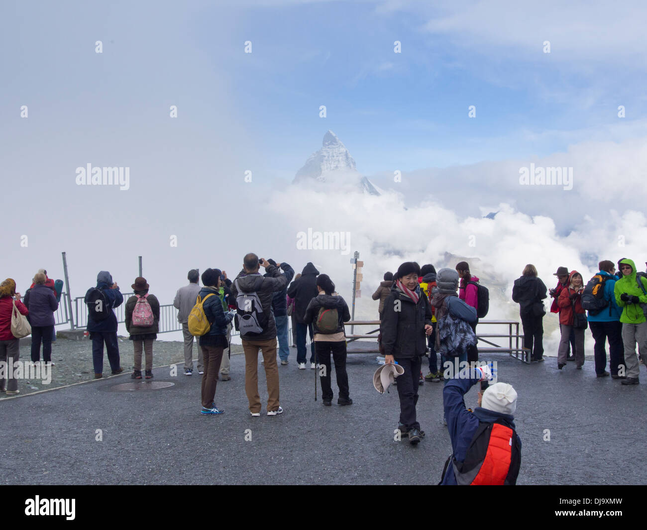 Asian tourists admiring the view of the alpine peak of Matterhorn in ...