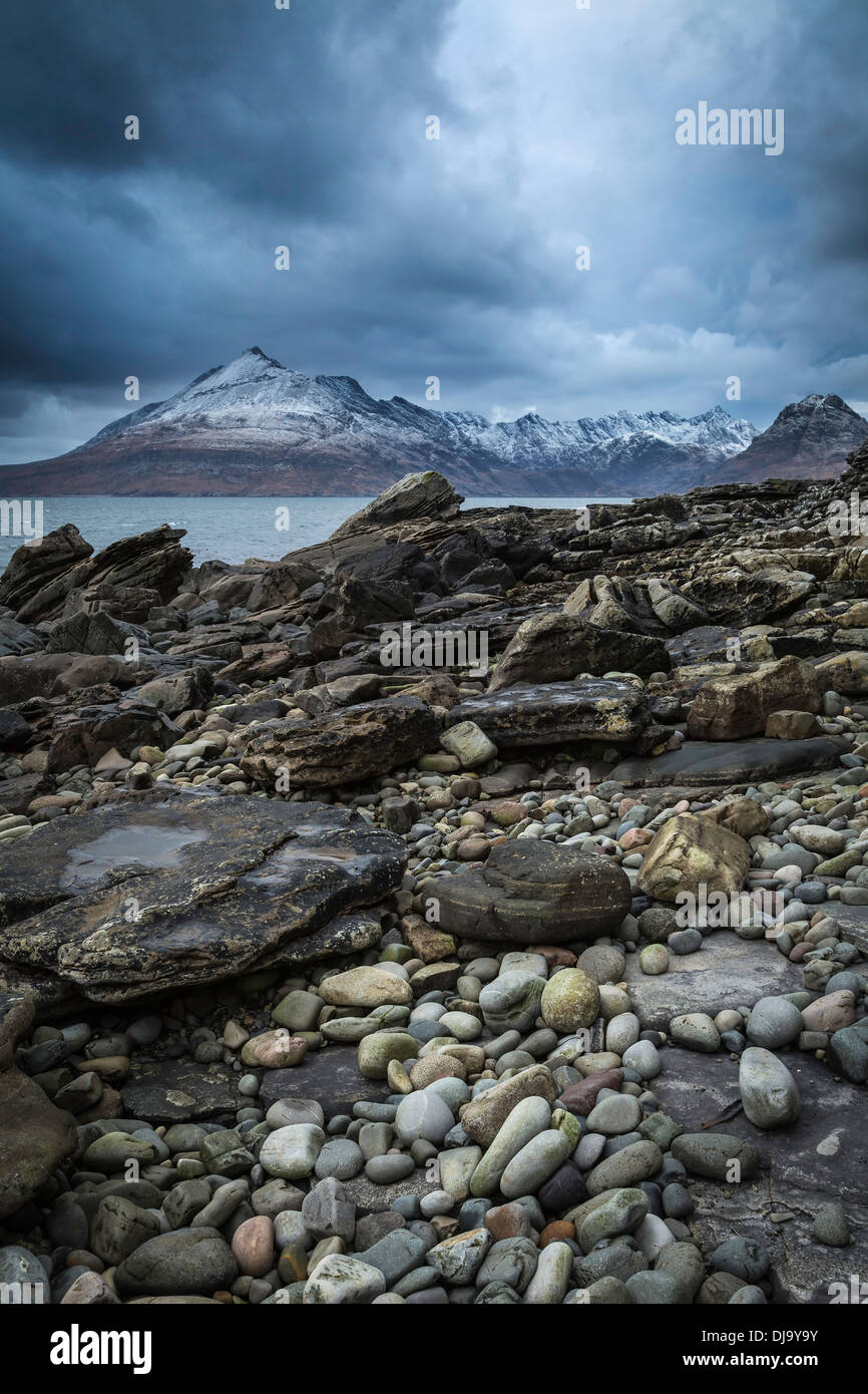Elgol beach under a stormy sky with snow dusted Cuillin Hills in the ...