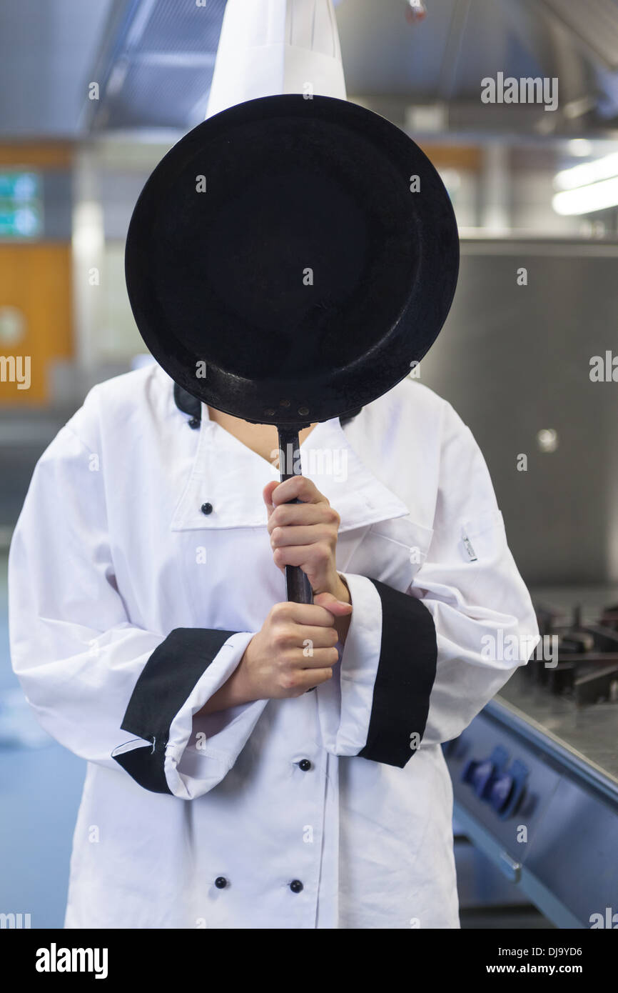 Chef covering face with pan standing in professional kitchen Stock ...