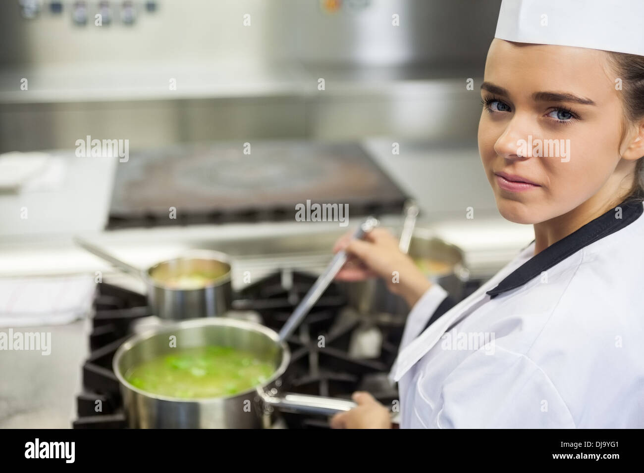 Young happy chef stirring sauce in professional kitchen Stock Photo - Alamy