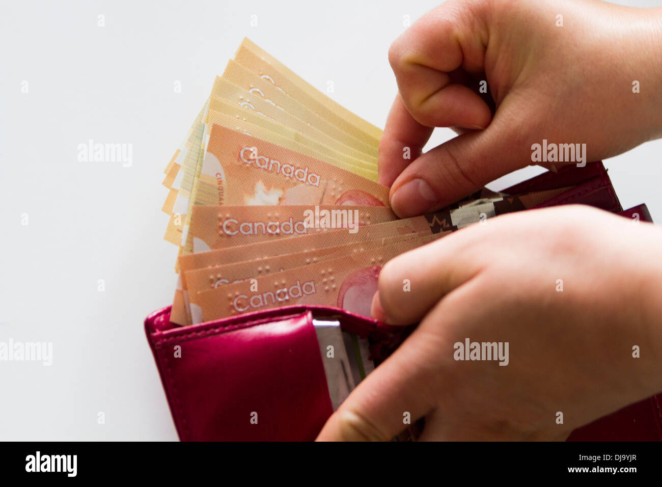 Human hand pulling money out of wallet Canadian wallet with Canadian ...