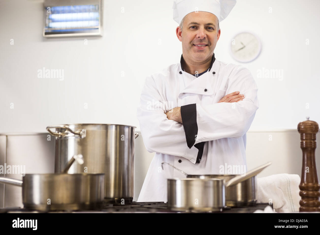 Smiling head chef standing arms crossed behind pot Stock Photo - Alamy