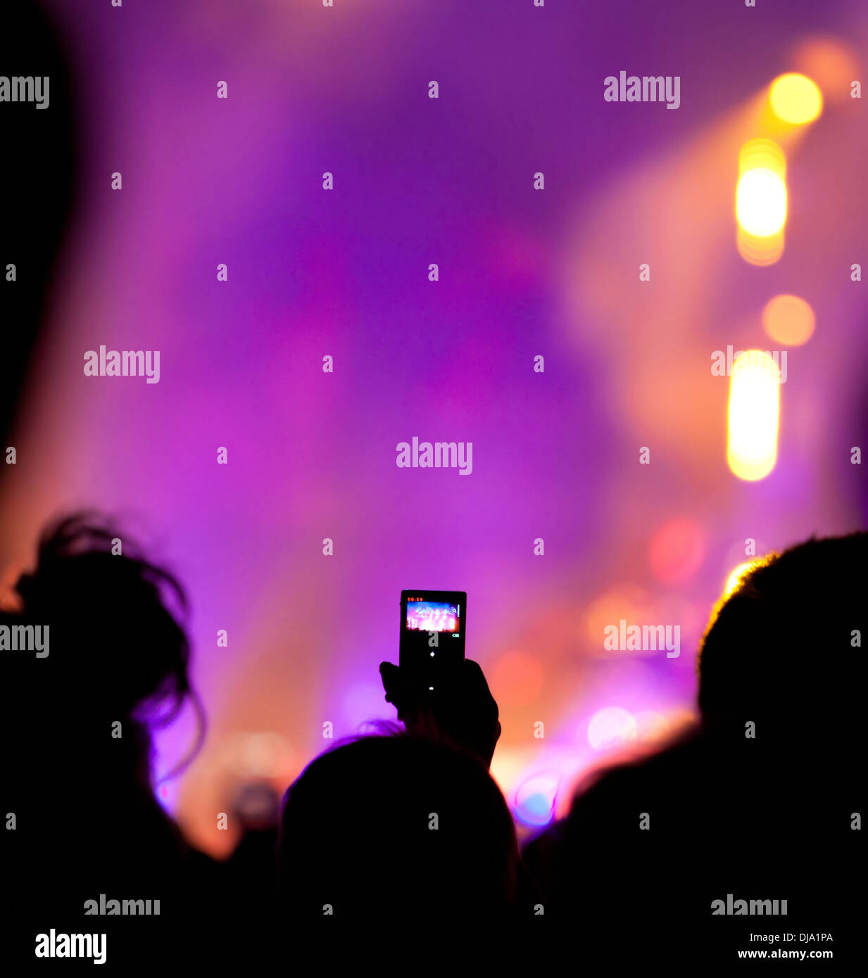 Cheering crowd in front of bright colorful stage lights Stock Photo - Alamy