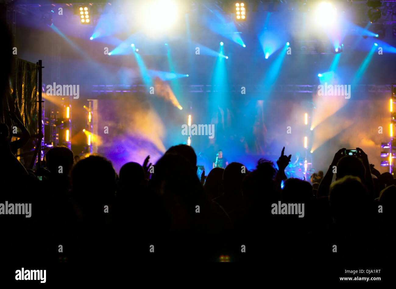 Cheering crowd in front of bright colorful stage lights Stock Photo - Alamy