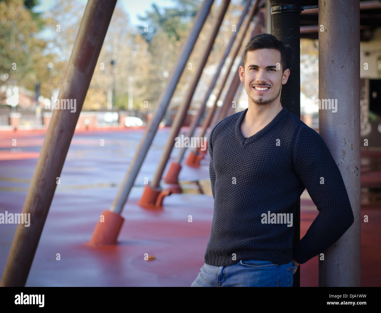 Smiling, friendly young man looking at camera, standing in urban ...