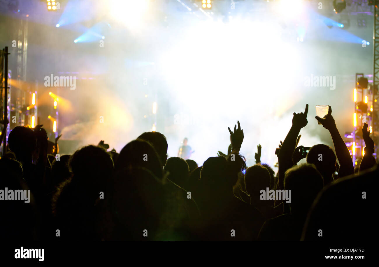 Cheering crowd in front of bright colorful stage lights Stock Photo - Alamy