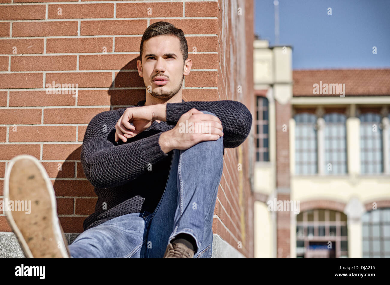Man sit against wall hi-res stock photography and images - Alamy
