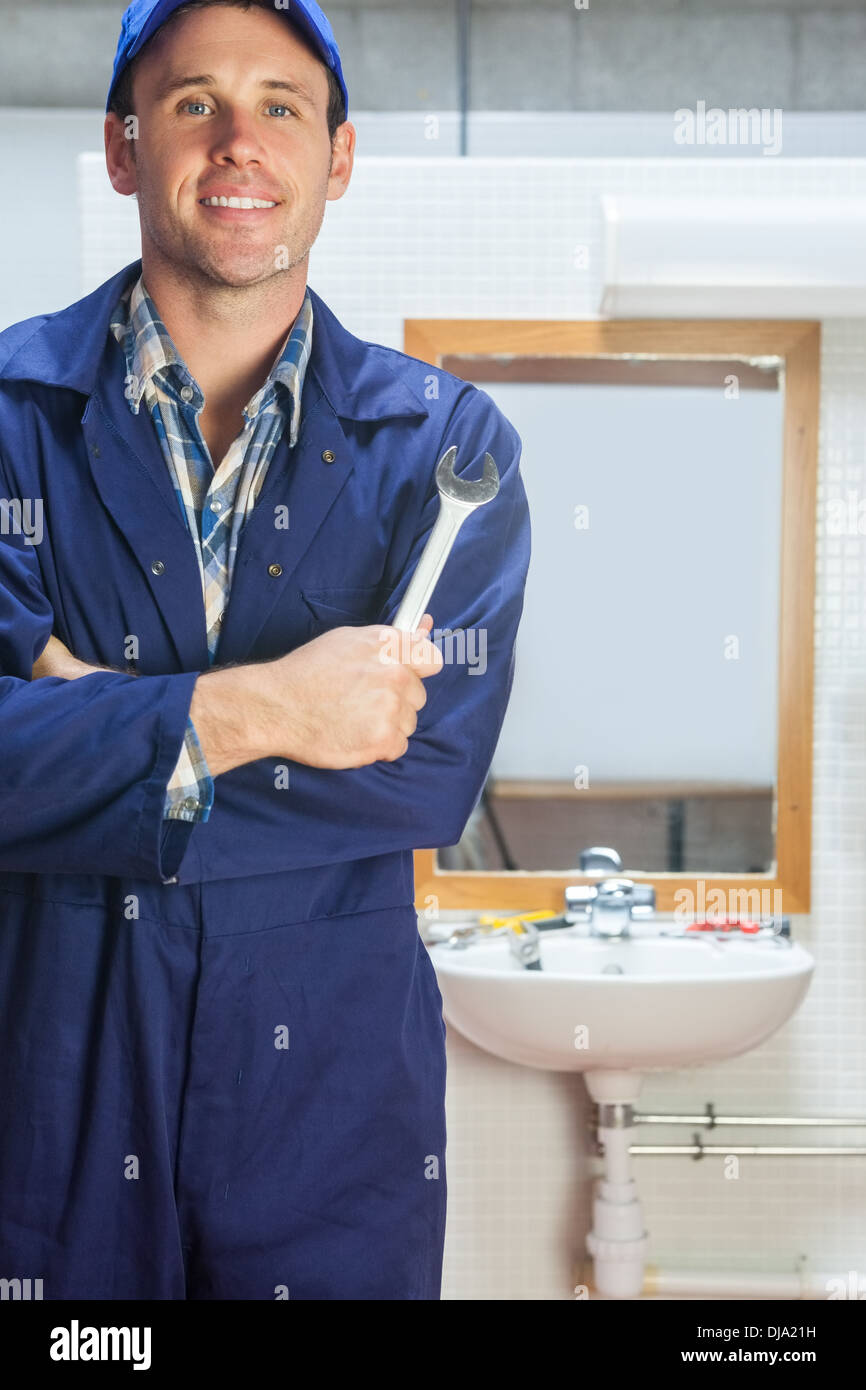 Smiling plumber posing with wrench Stock Photo - Alamy