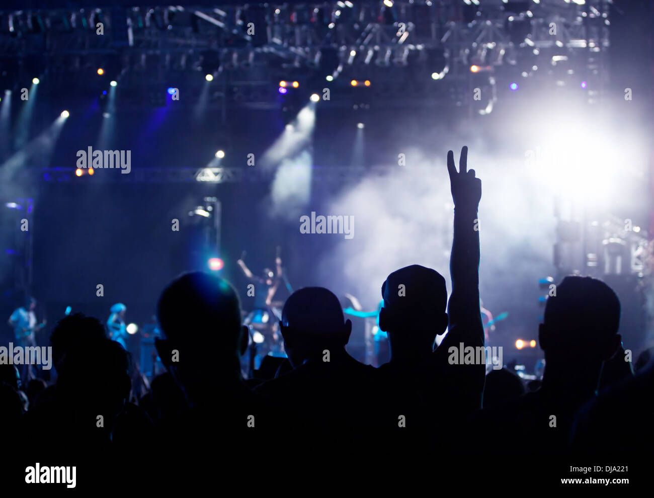 Cheering crowd in front of bright colorful stage lights Stock Photo - Alamy