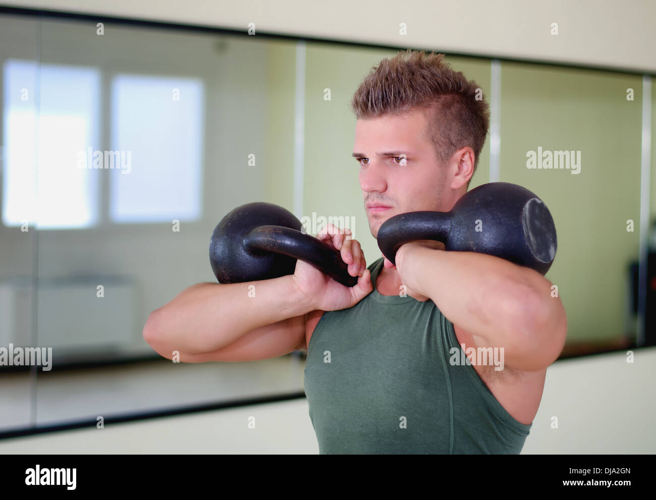 Attractive young athletic man exercising in gym, working out using ...