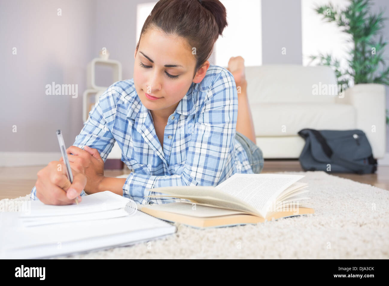 Gorgeous brunette student doing homework lying on the floor Stock Photo ...