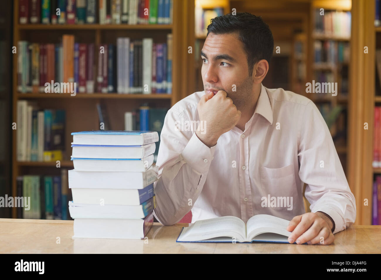 Attractive man sitting in library in front of an opened book Stock ...