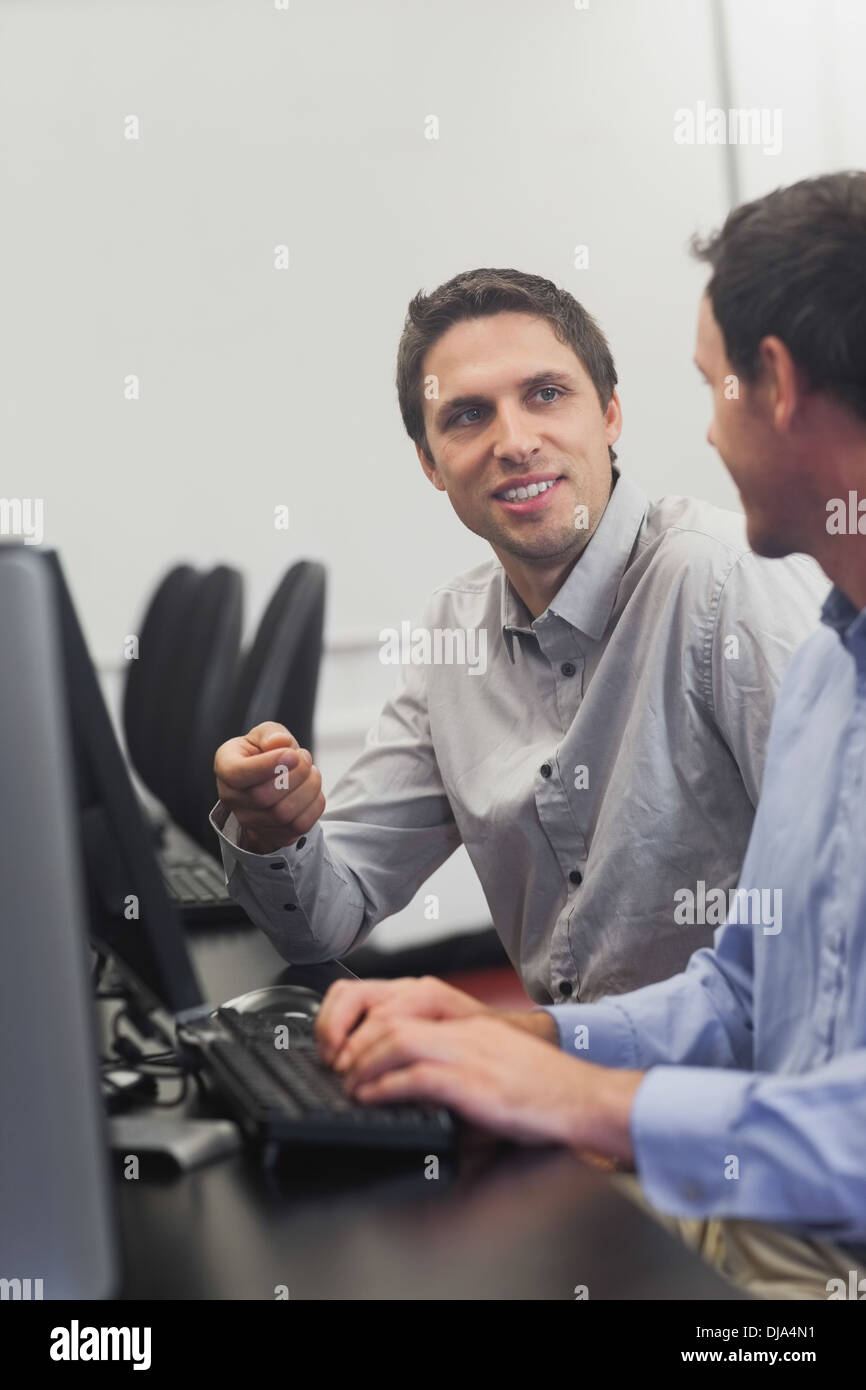 Two friendly men talking sitting in front of a computer Stock Photo - Alamy